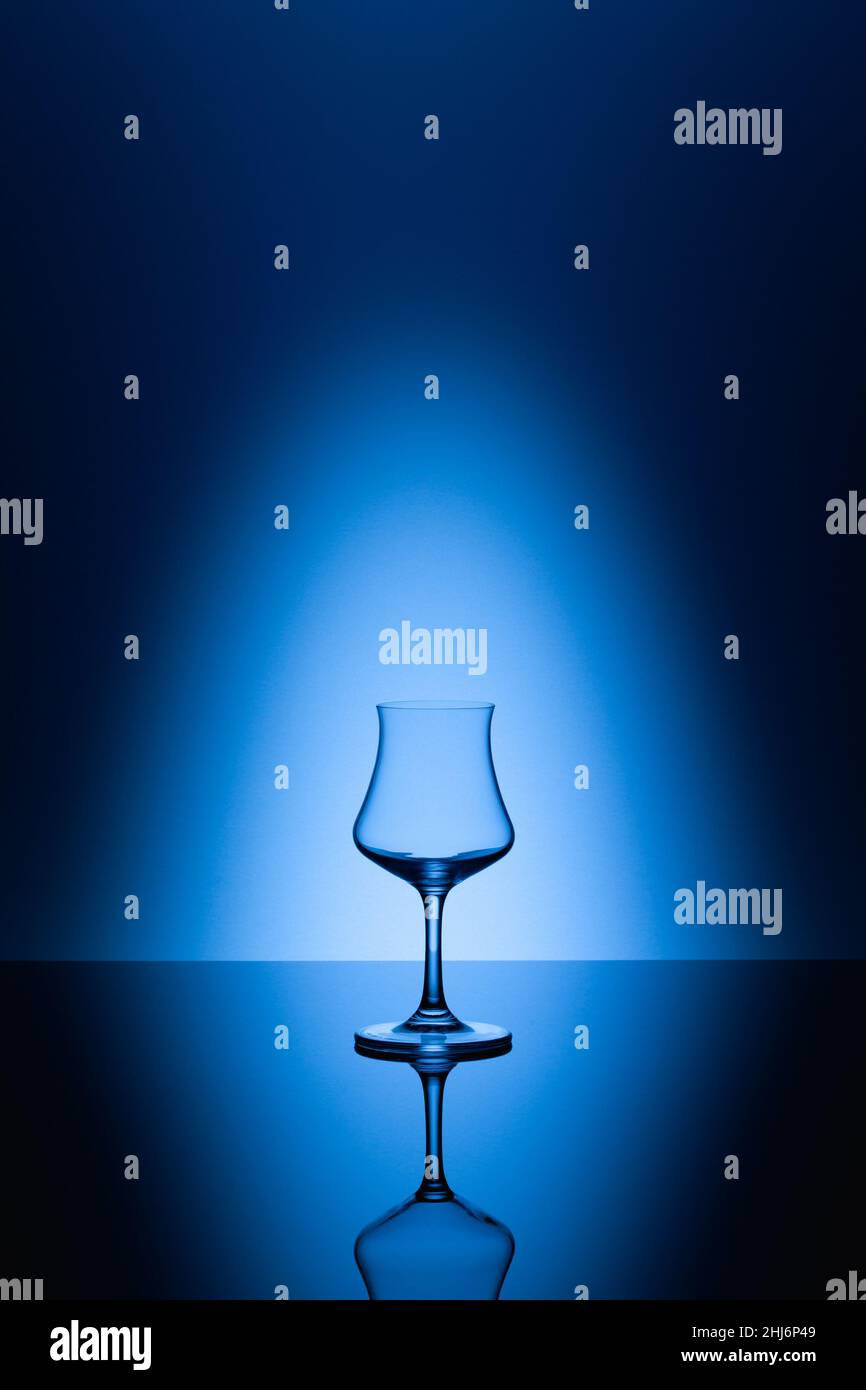 Rum tasting glass on the glass table and blue background Stock Photo ...