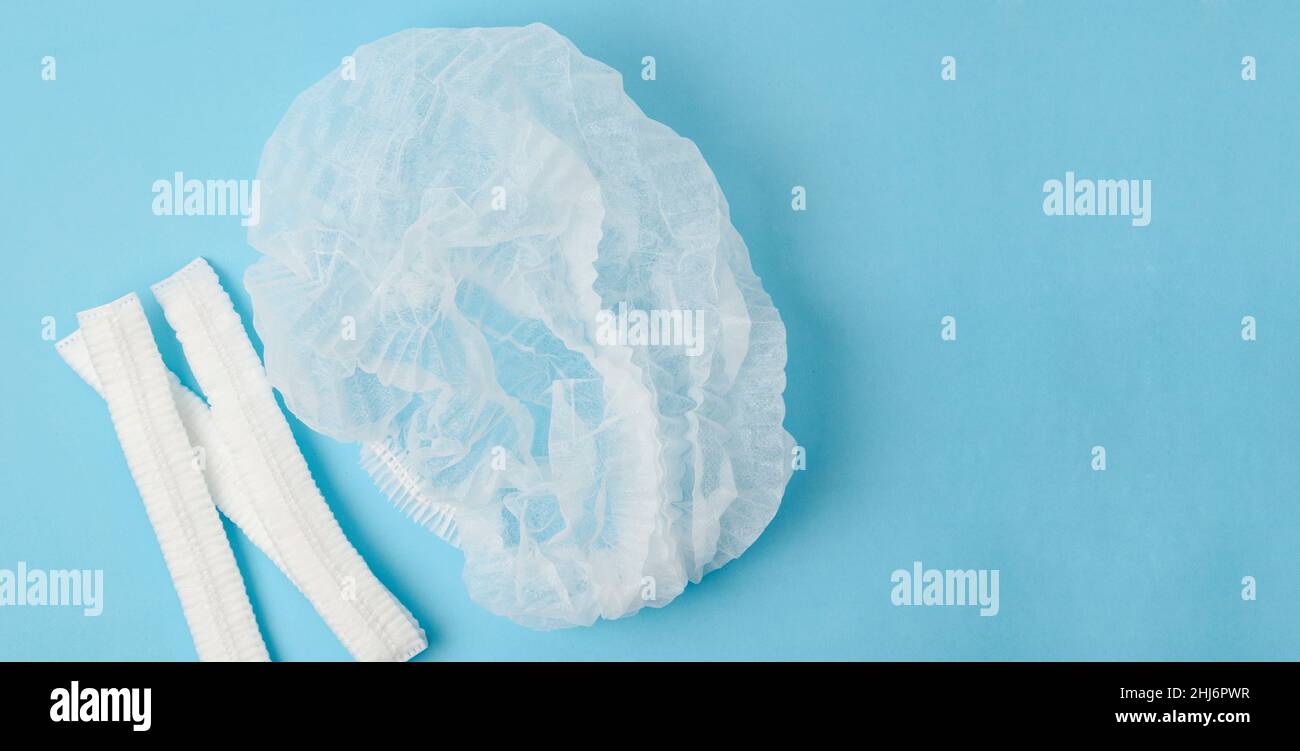 The white medical disposable cap on blue background with empty space ...