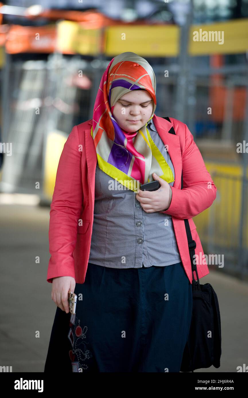 Rotterdam, Netherlands. Moslima woman wearing a headscarf walking with ...
