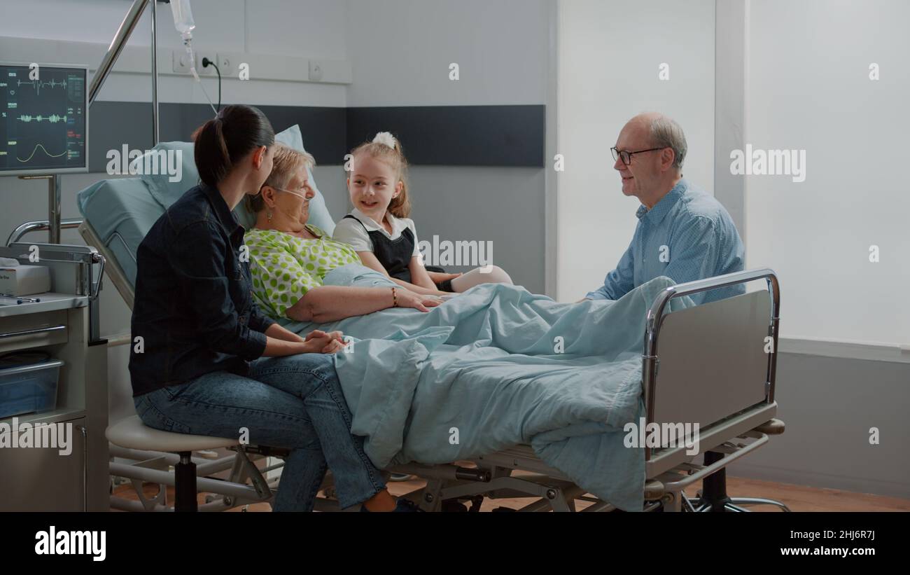Niece hugging sick woman at family visit in hospital ward, child and ...