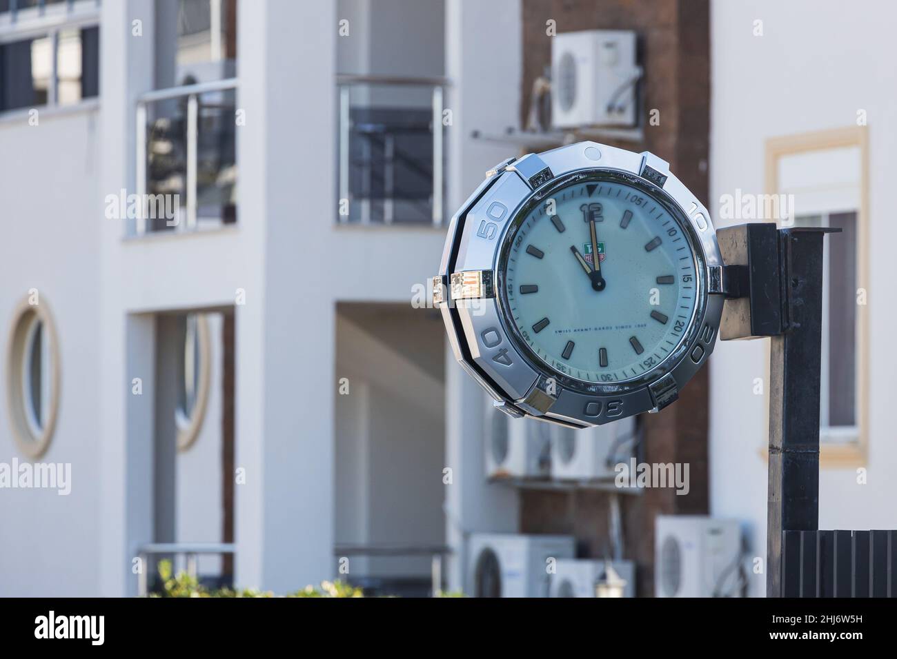 Close-up of a round street clock hanging on a pillar against the ...