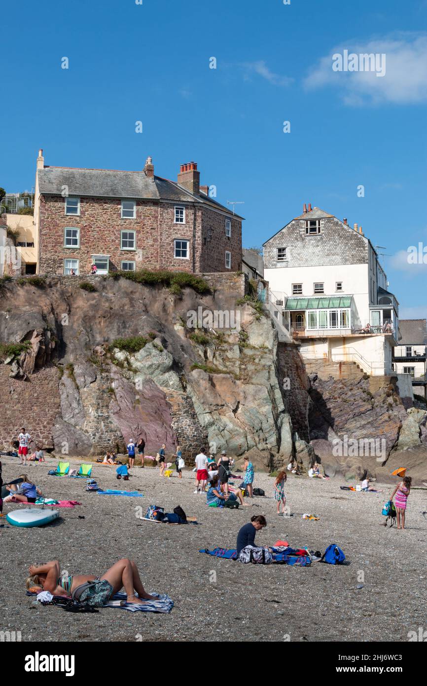 Sunbathers and paddleboarders enjoy a sunny summer day on Cawsand beach ...