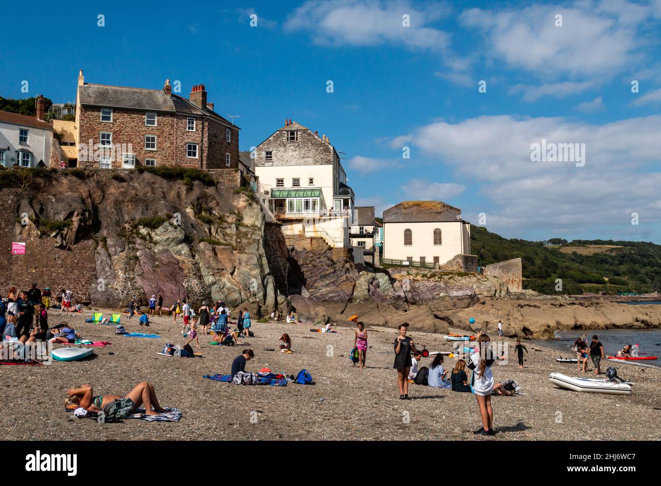 Sunbathers and paddleboarders enjoy a sunny summer day on Cawsand beach ...