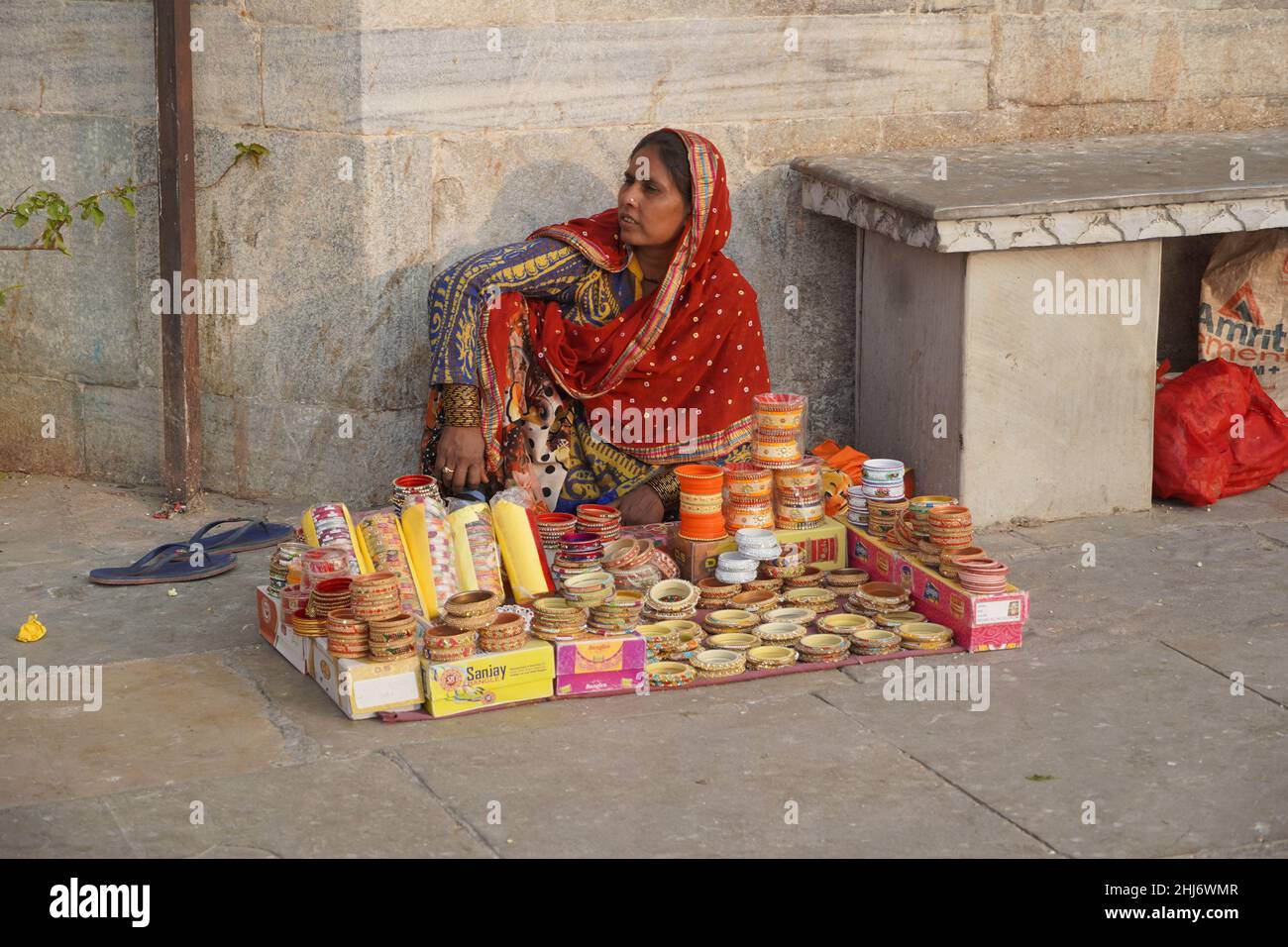 An old woman sitting on Indian street market and selling colorful ...