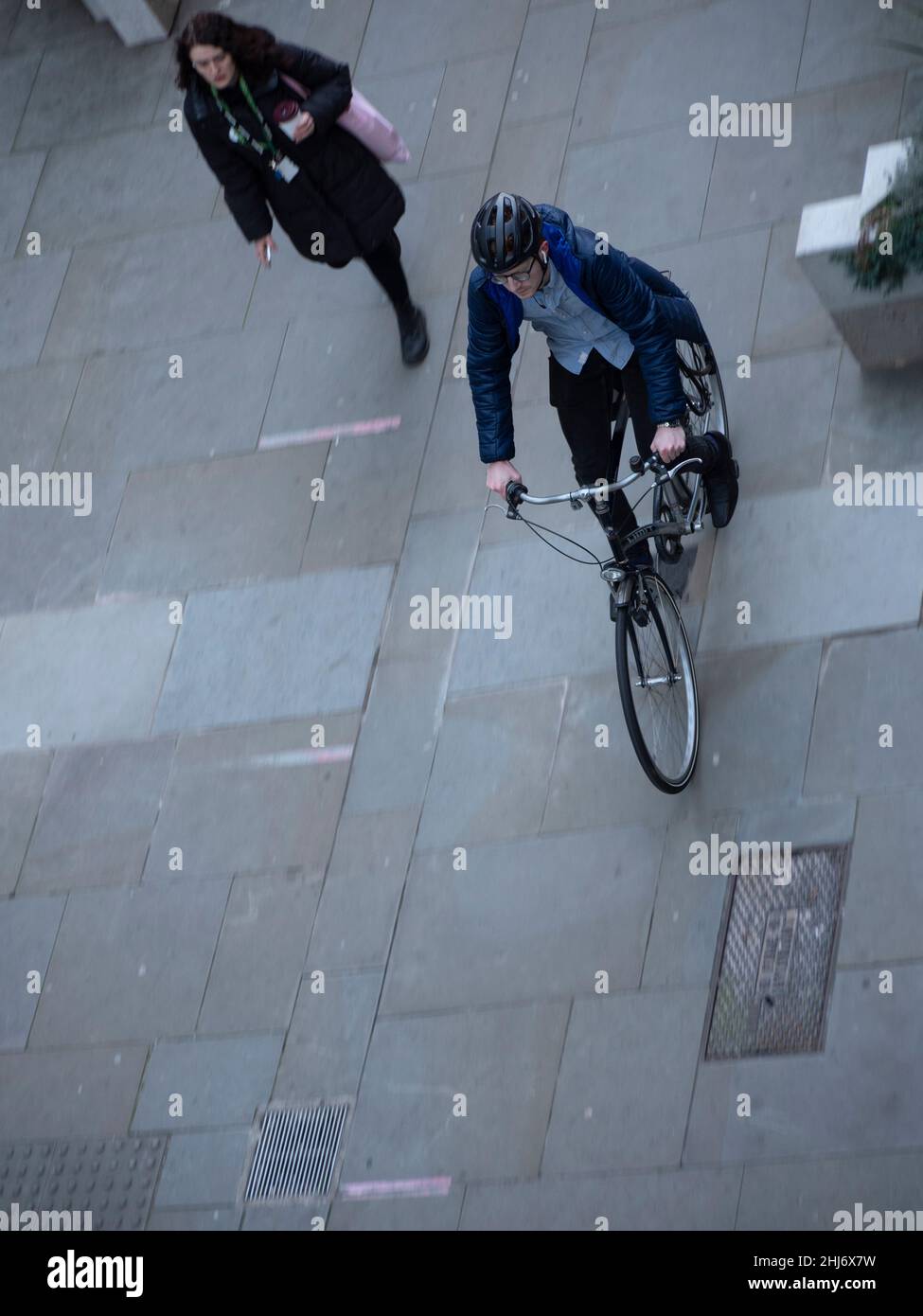 Cyclist riding bike on pavement, Barbican, London Stock Photo - Alamy