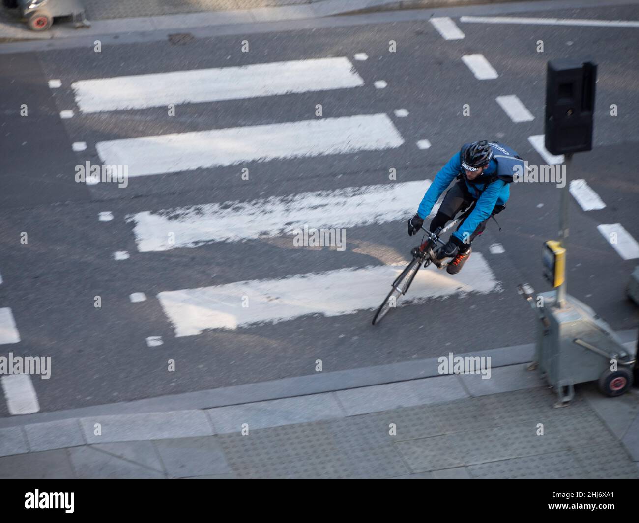 Cyclist riding bike on pavement, near pedestrian zebra crossing ...