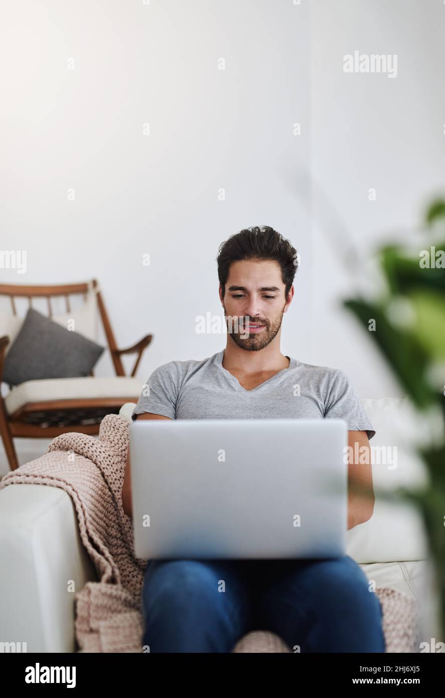 Logging into his personal email account. Shot of a young man browsing ...