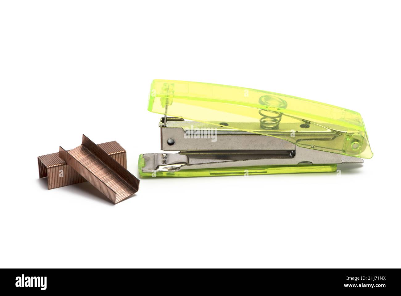 Close up of transparent neon green stapler next to bronze refill ...