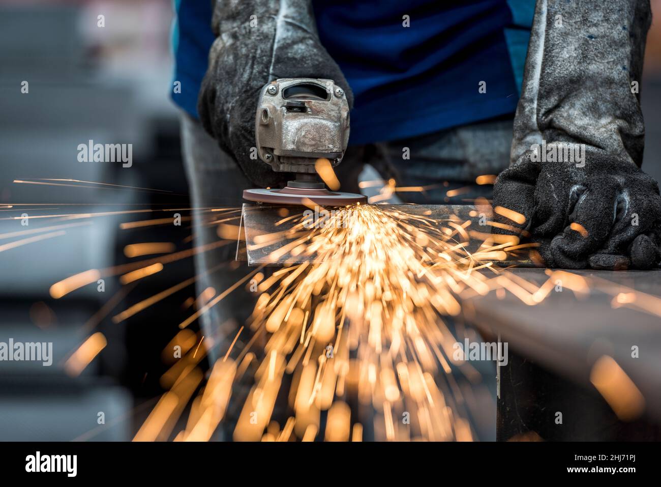 Industrial worker cutting metal with many sharp sparks Stock Photo - Alamy