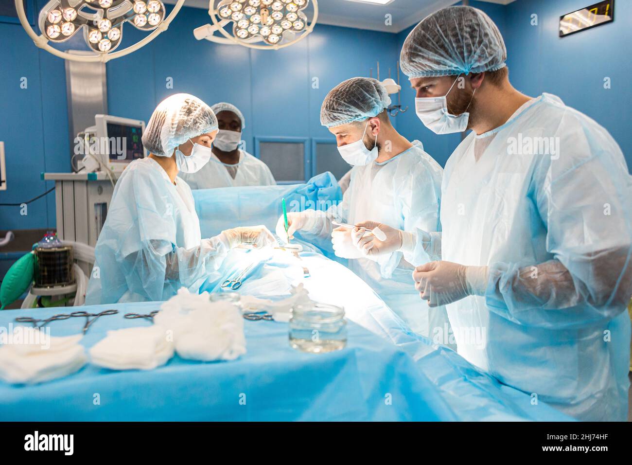 An international team of doctors performs a complex surgical operation on a patient under ...