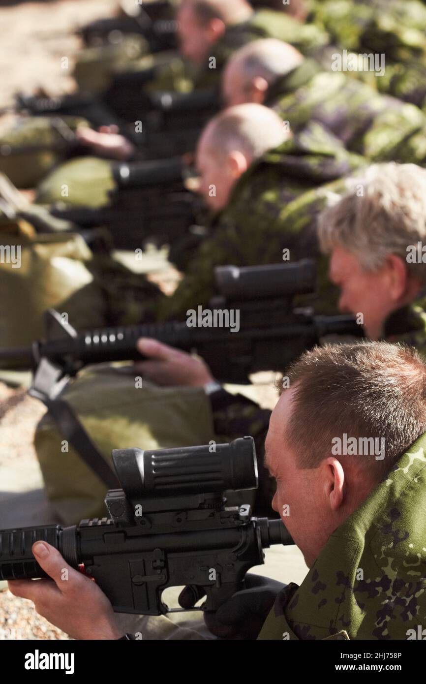 Aiming low. A line of soldiers lying and aiming with their guns Stock ...