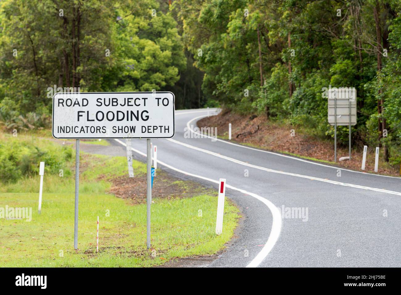 A flood warning sign on a flood risk, low lying road in regional ...