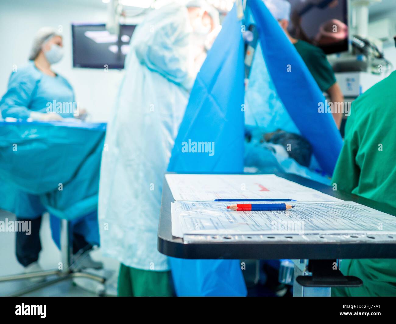 A red and blue pencil lies on the surgical protocol on a table in the ...