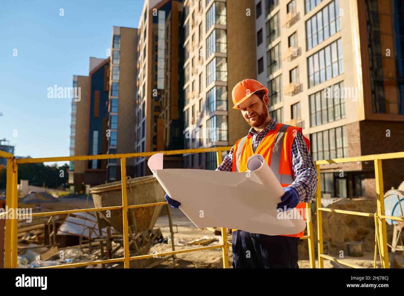 Builder or engineer holding blueprint standing outside Stock Photo - Alamy