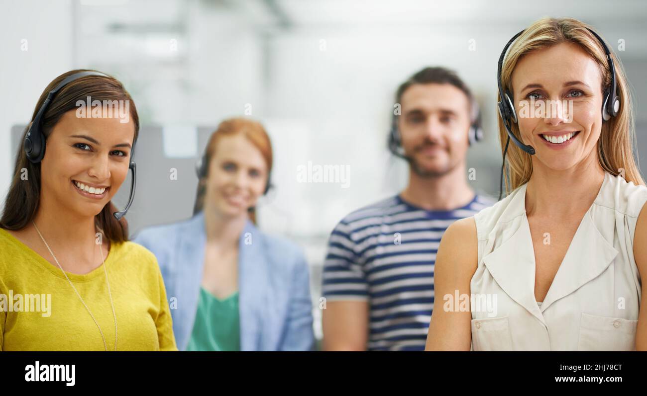 We're invincible. A group of colleagues standing with headsets at the ...