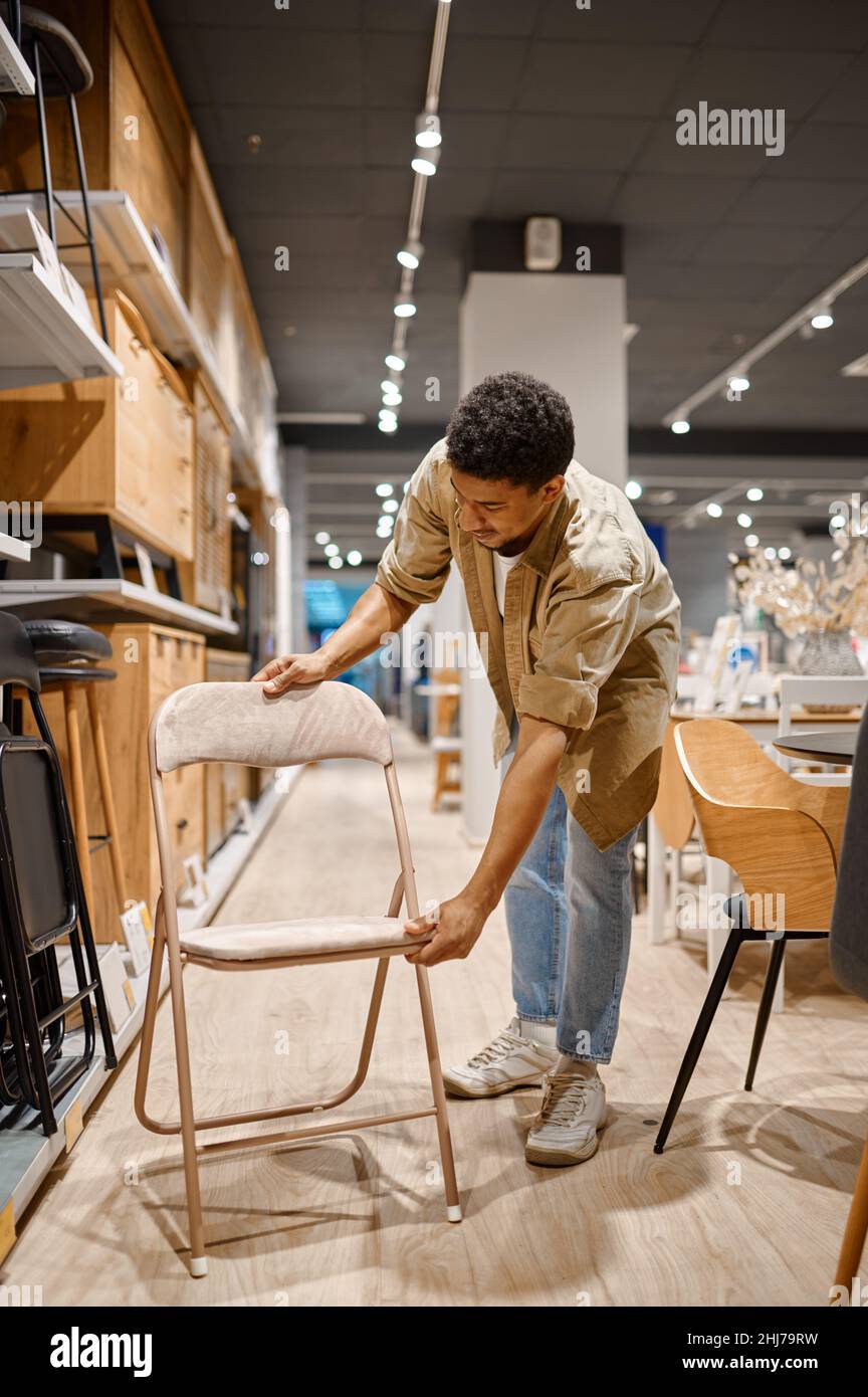 Man is buying folding chair for garden Stock Photo - Alamy