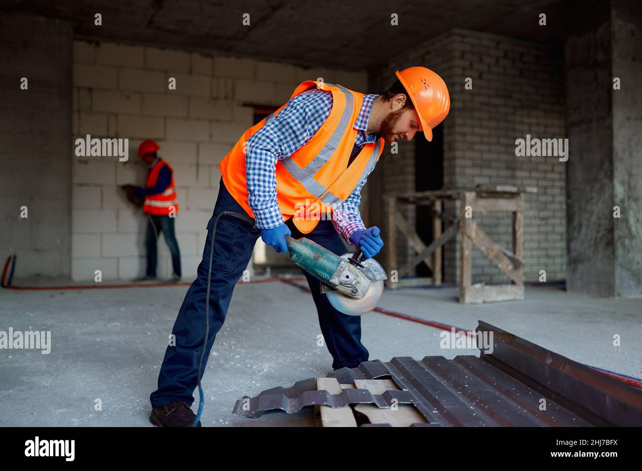 Builder worker with grinder machine cutting metal Stock Photo - Alamy