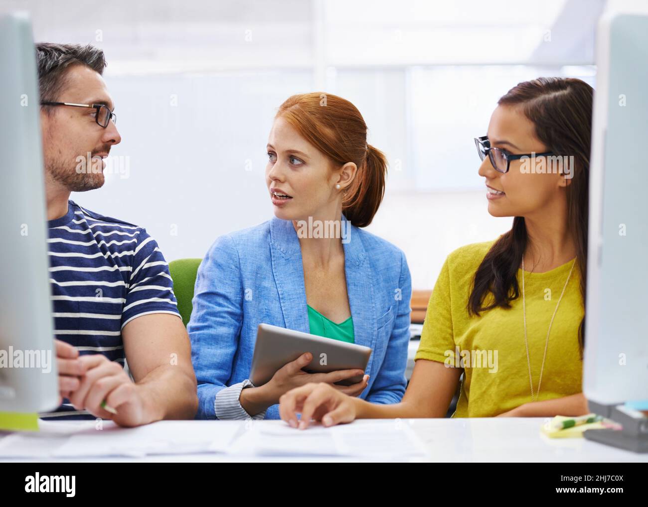 Is it really due now. Three coworkers discussing deadlines at their ...