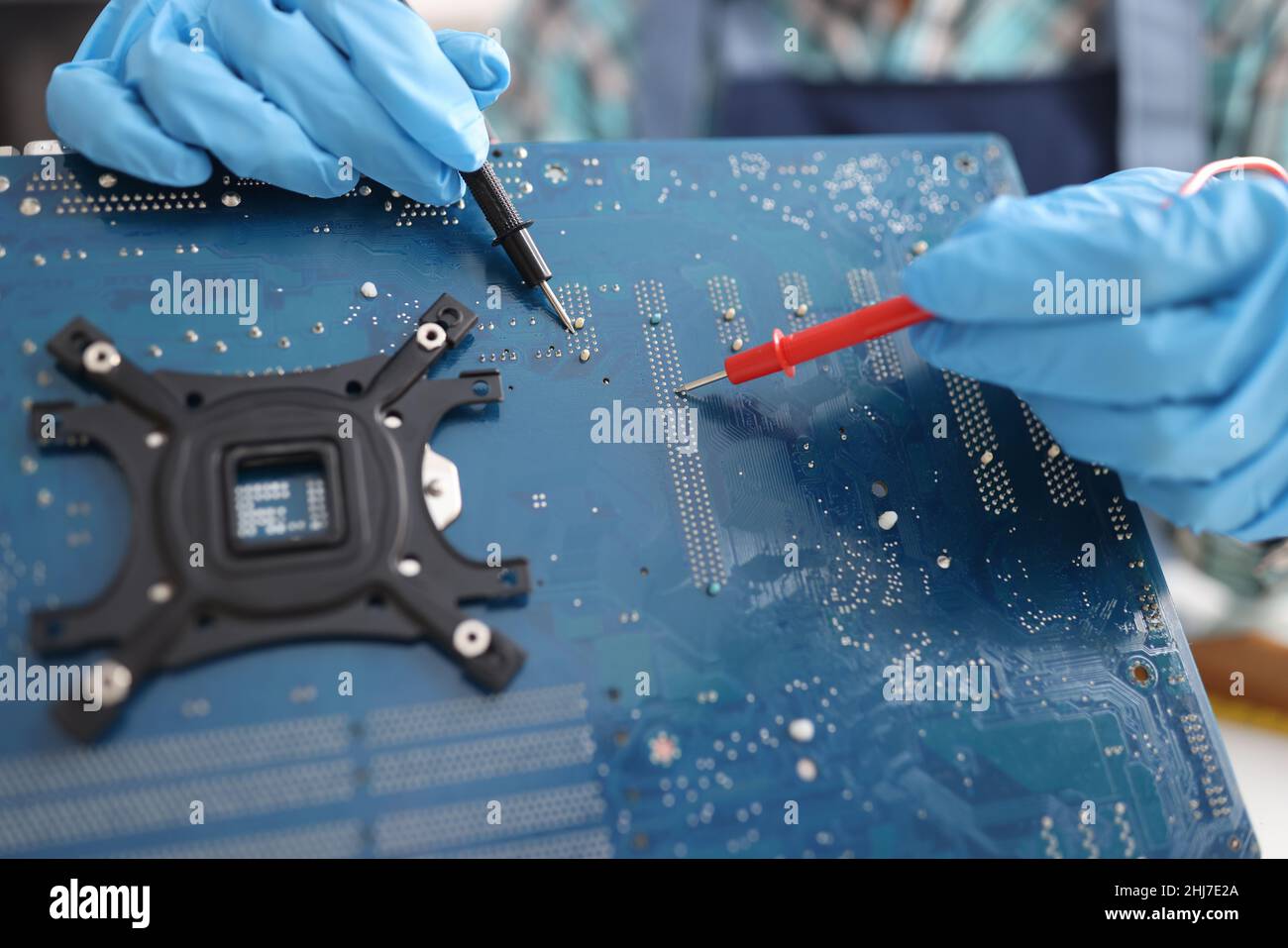 Repairman diagnosing breakdown in computer motherboard using tester ...