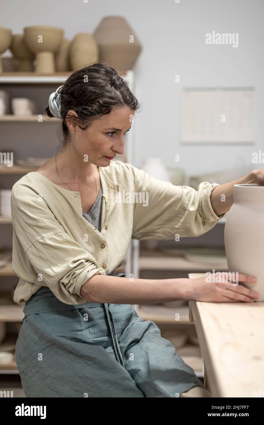 Woman holding pottery instrument for scraping, smoothing, shaping and ...