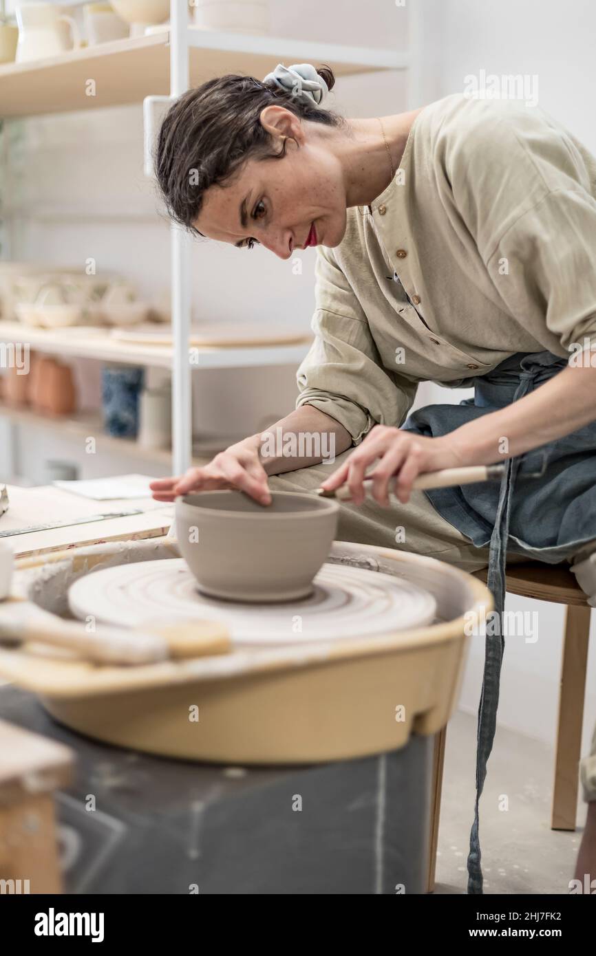 Female potter modeling clay bowl in workshop - Artisan work and ...