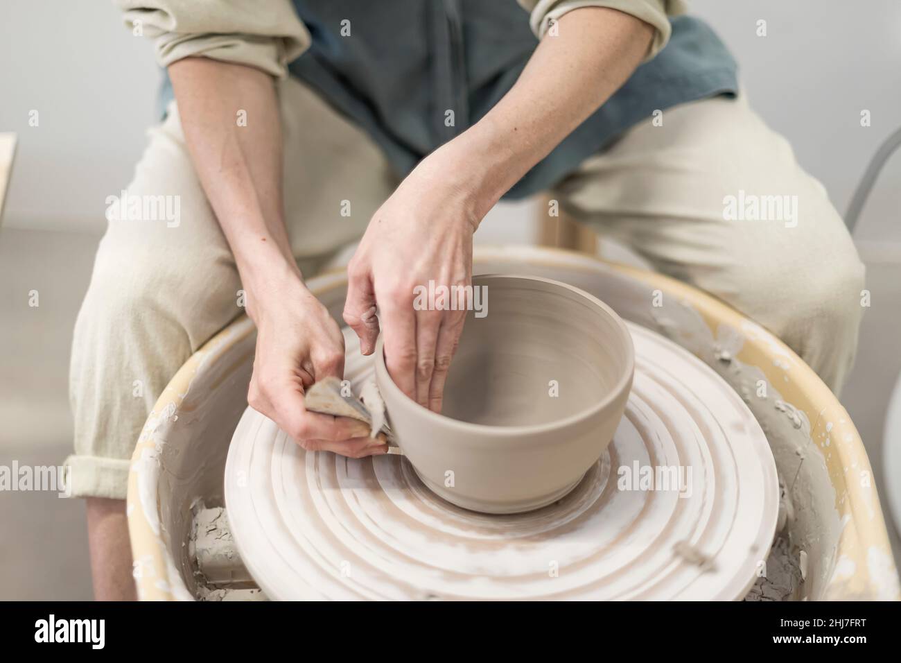 Female potter modeling clay bowl in workshop - Artisan work and ...