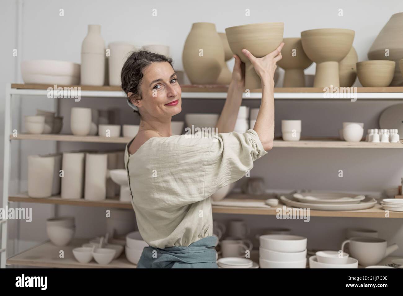 Female ceramist at indoors holding handmade clay product. Conception of ...