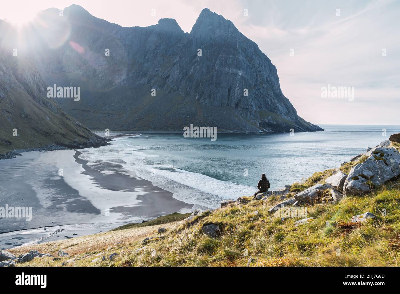 Relaxed man sitting watching a sunset on a beach in norway Stock Photo ...