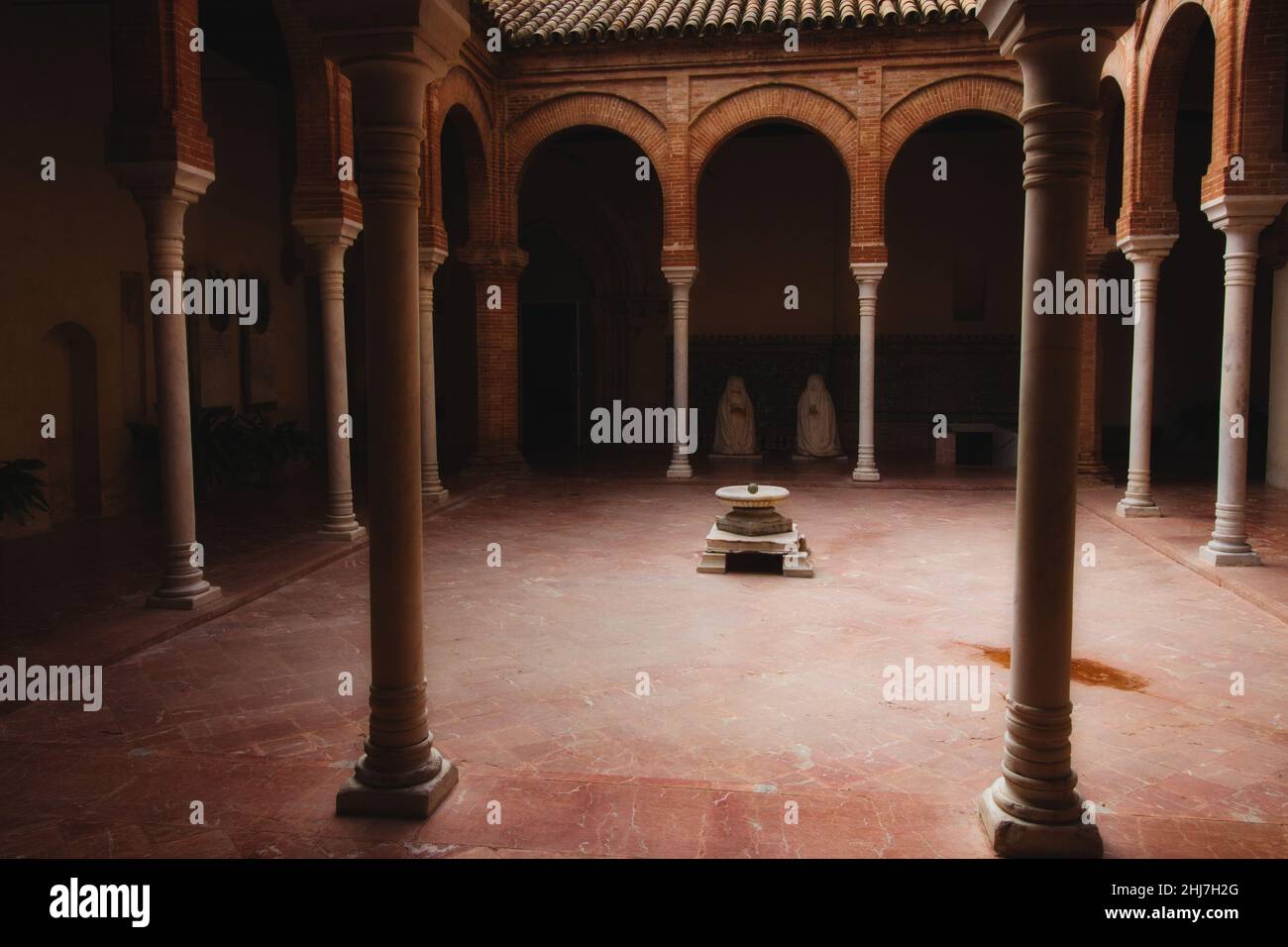 A traditional interior patio with old-fashioned columns and arches ...