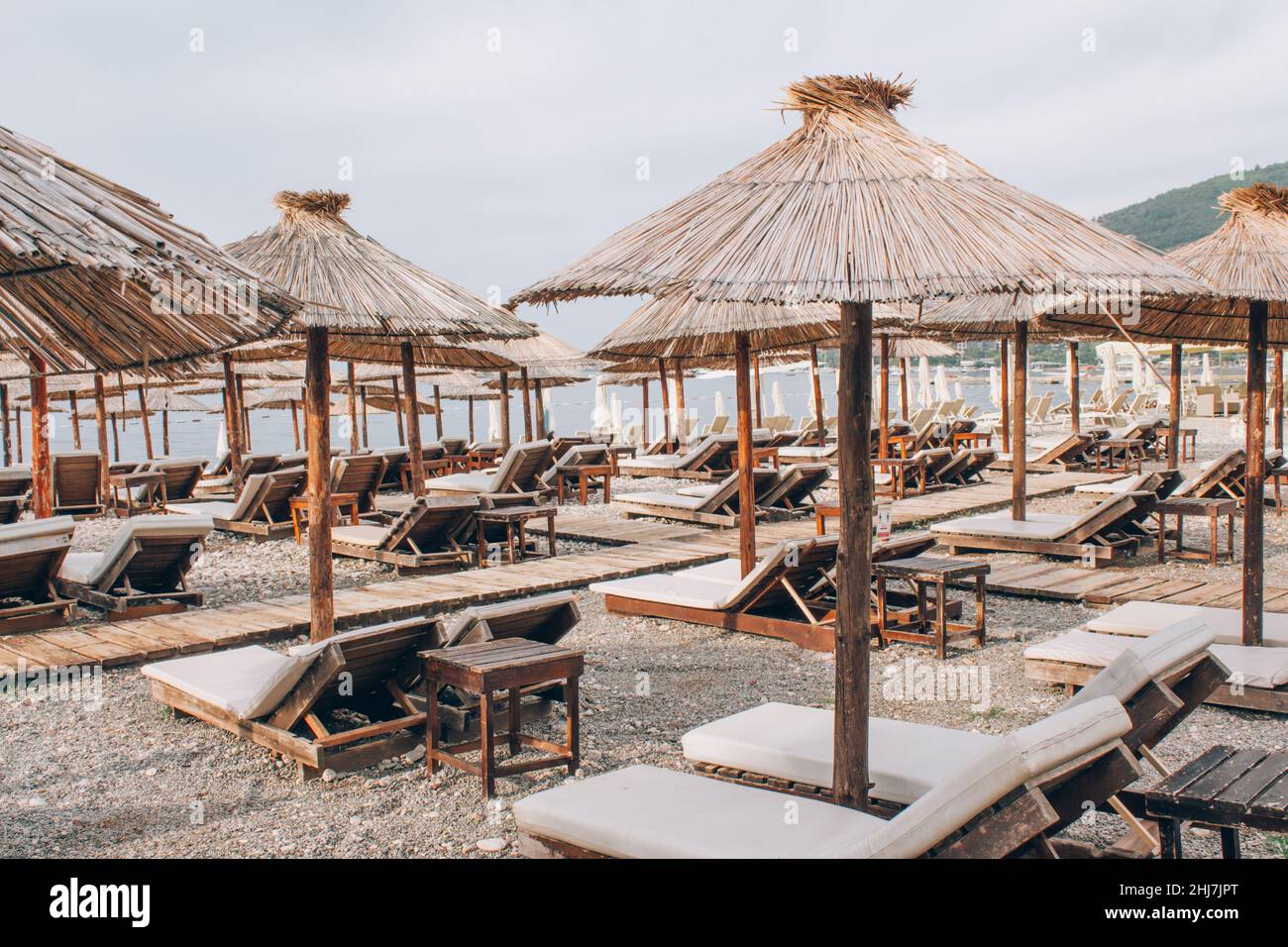 Sea beach with sunbeds and beach umbrellas in Budva, view from Adriatic sea coast, summer ...
