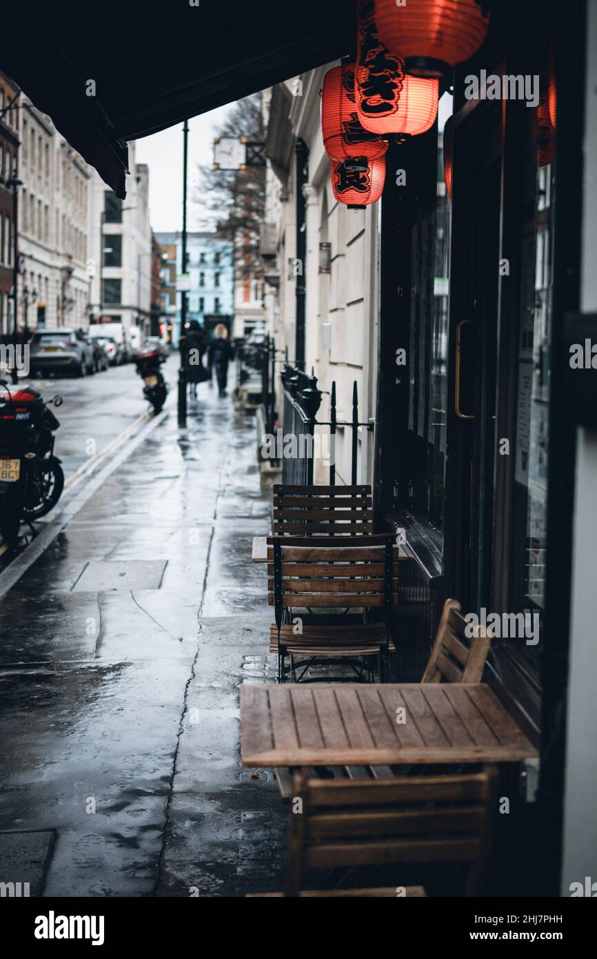 Vertical shot of a pavement surrounded by shops on a rainy day in ...