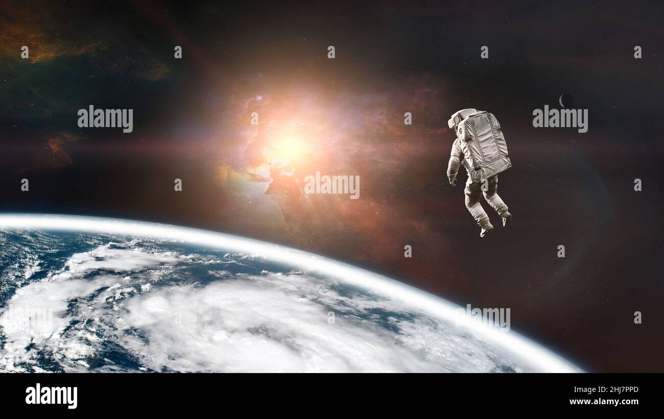 Spaceman on low-orbit of Earth planet with sun light. Elements of this ...