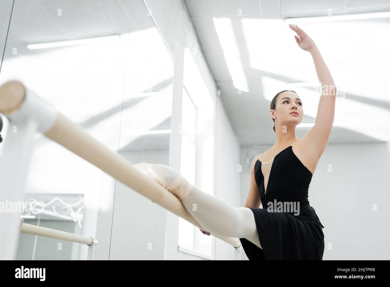low angle view of young dancer stretching in ballet studio Stock Photo ...