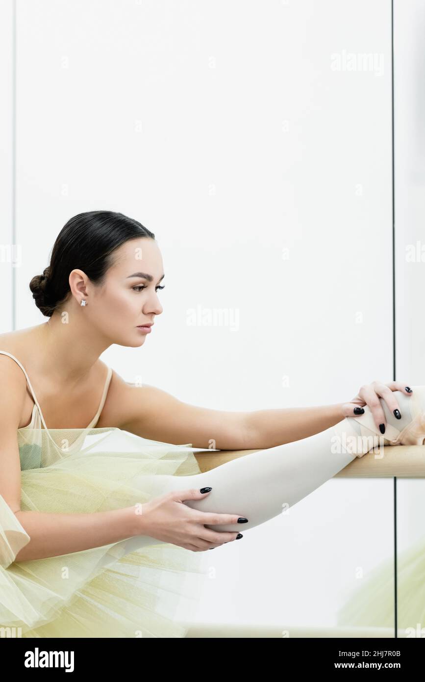 young ballerina stretching leg at barre in dance studio Stock Photo - Alamy