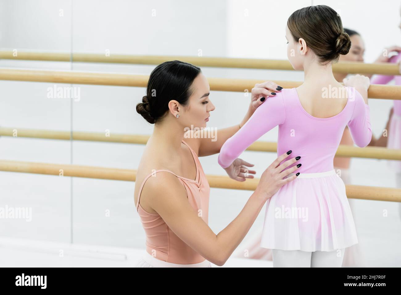 young choreographer teaching girl during rehearsal in ballet school ...