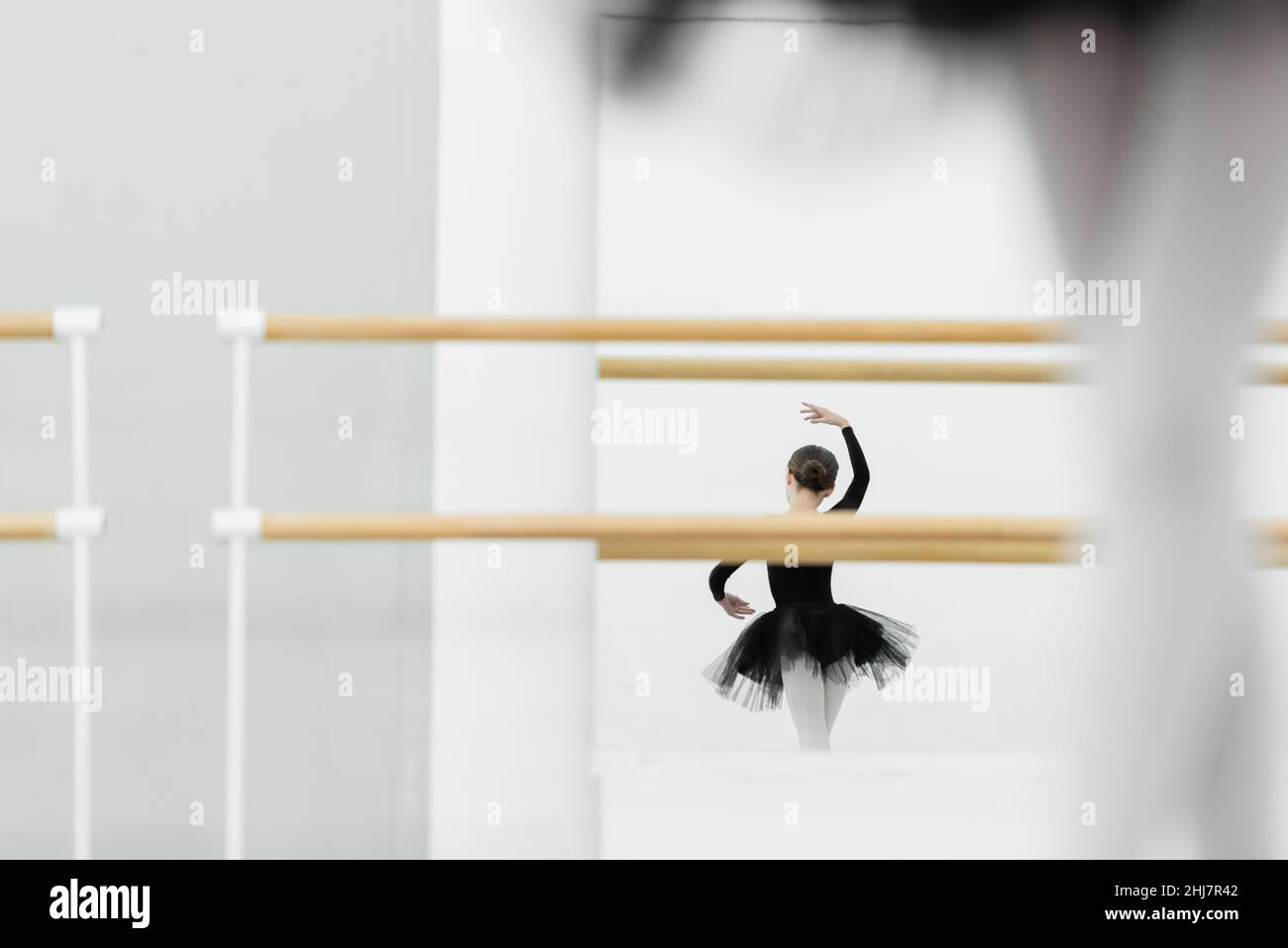 mirror reflection of girl dancing in ballet studio, blurred foreground ...