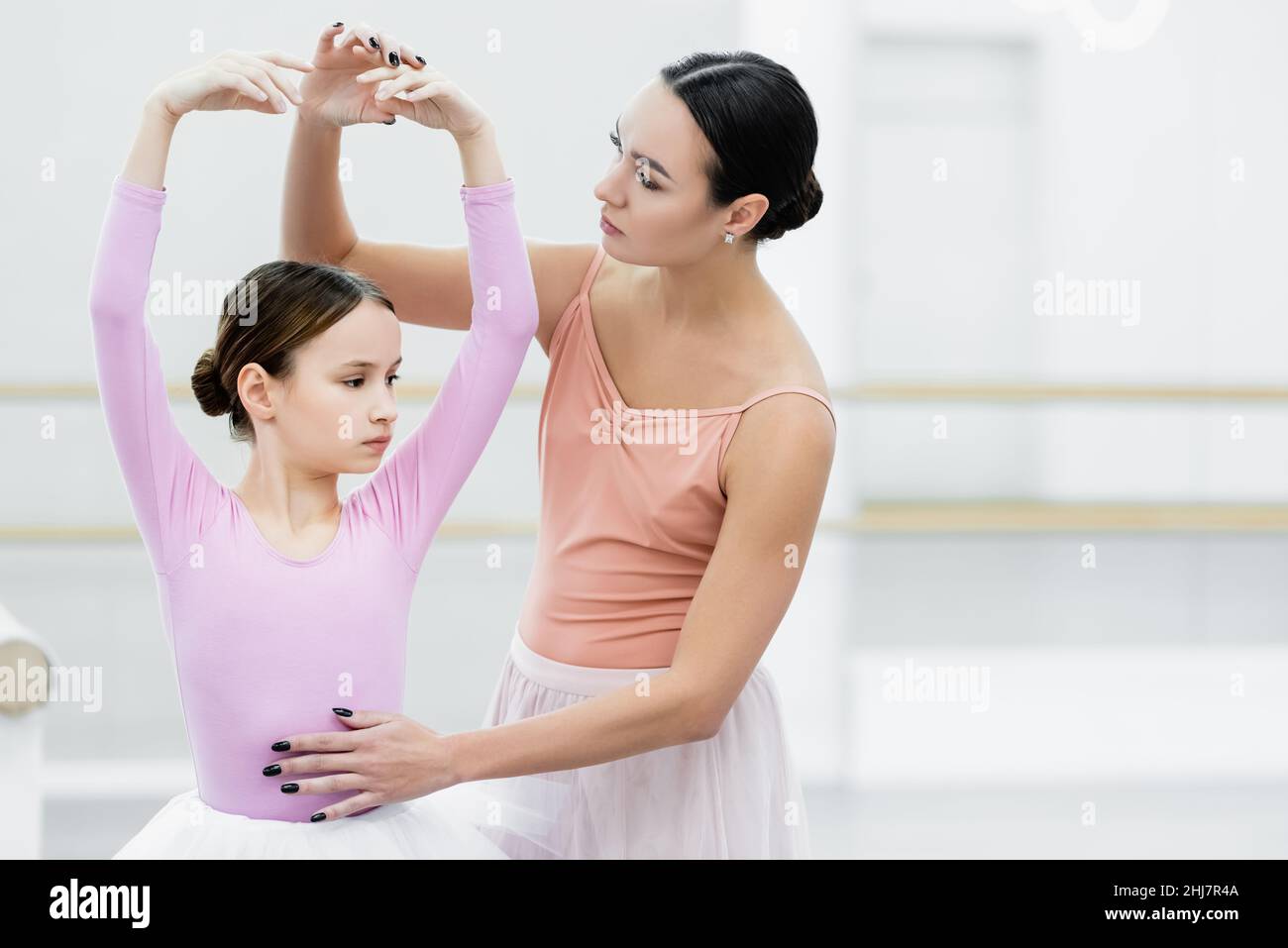 preteen girl practicing choreographic elements near young ballet master ...