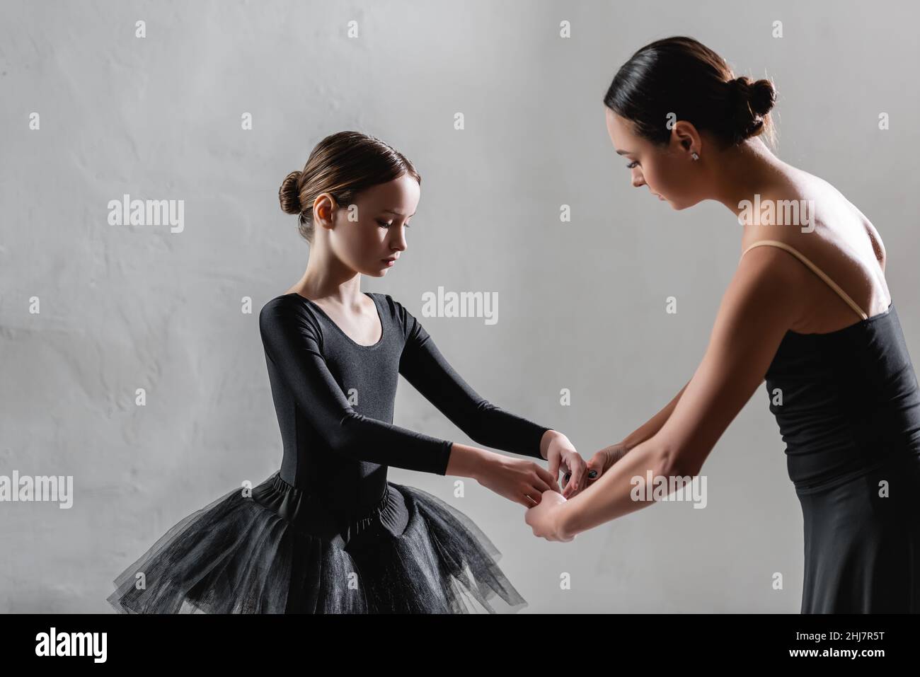 ballet teacher showing choreographic element to girl in black tutu on ...
