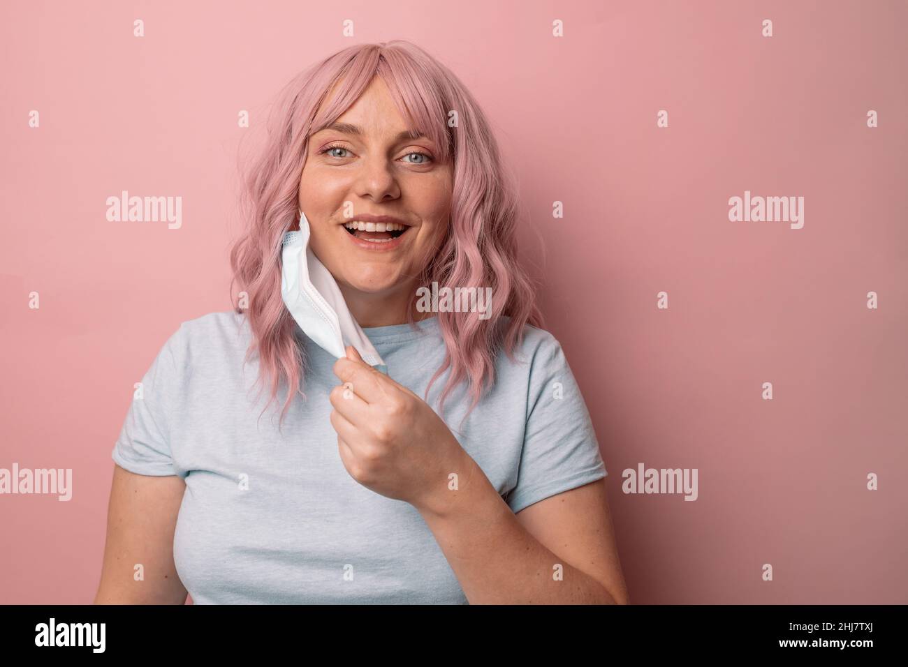Portrait of woman taking off face mask after the end of lockdown. Mask ...