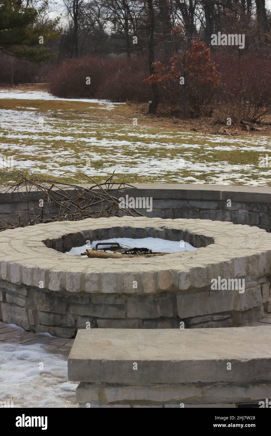 Stone campfire ring with a fireplace, logs, and seating Stock Photo - Alamy