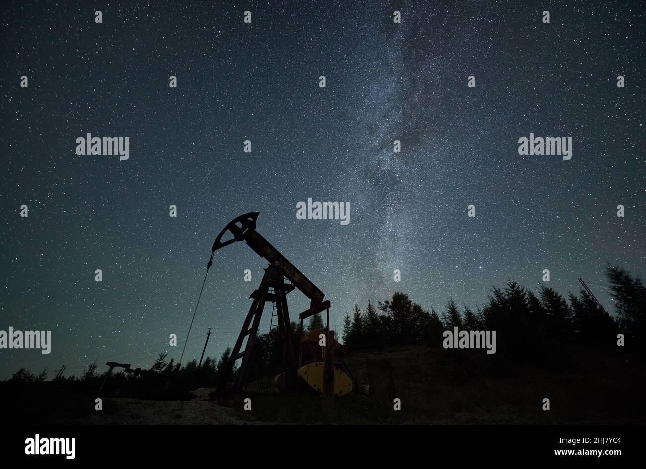 Operation of oil pump in borehole at night time under beautiful starry ...