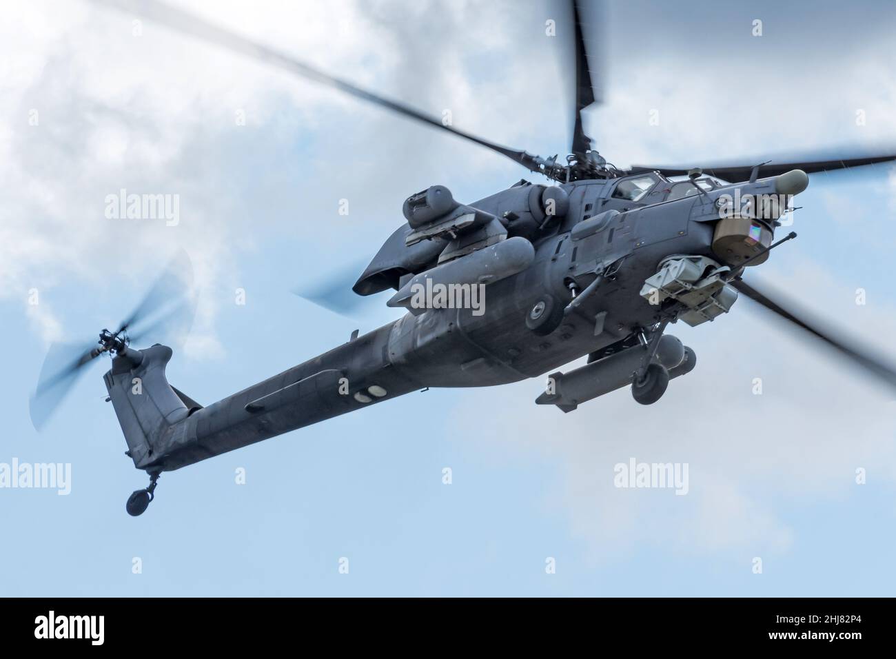 Military helicopter in the sky on a combat mission with weapons Stock ...