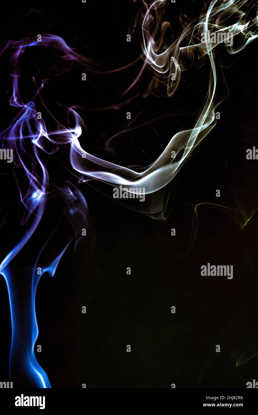 Abstract light colored smoke on dark background Stock Photo - Alamy
