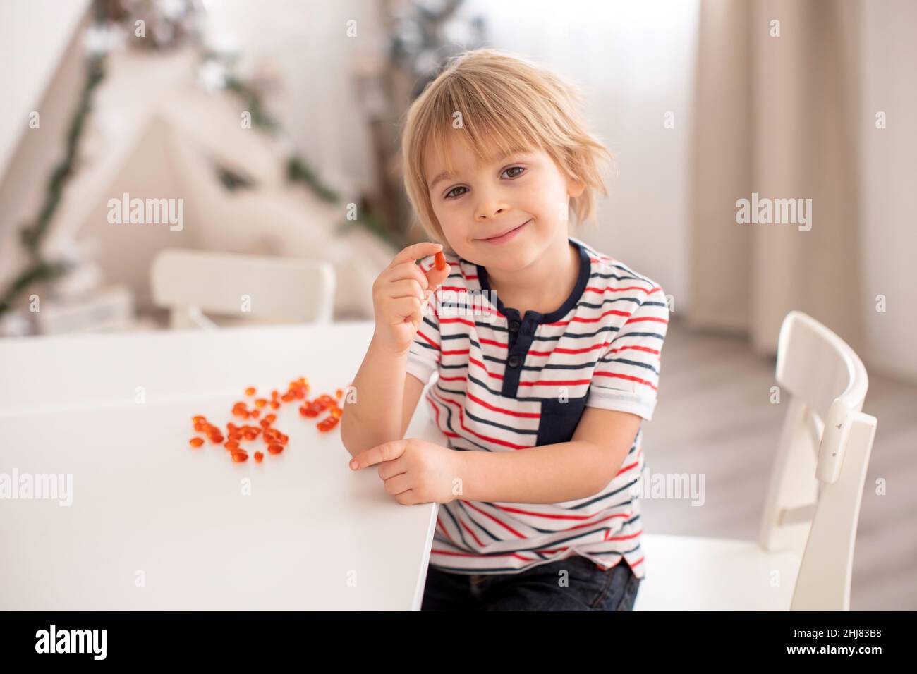 Cute little child, toddler boy, eating alfa omega 3 child suplement ...