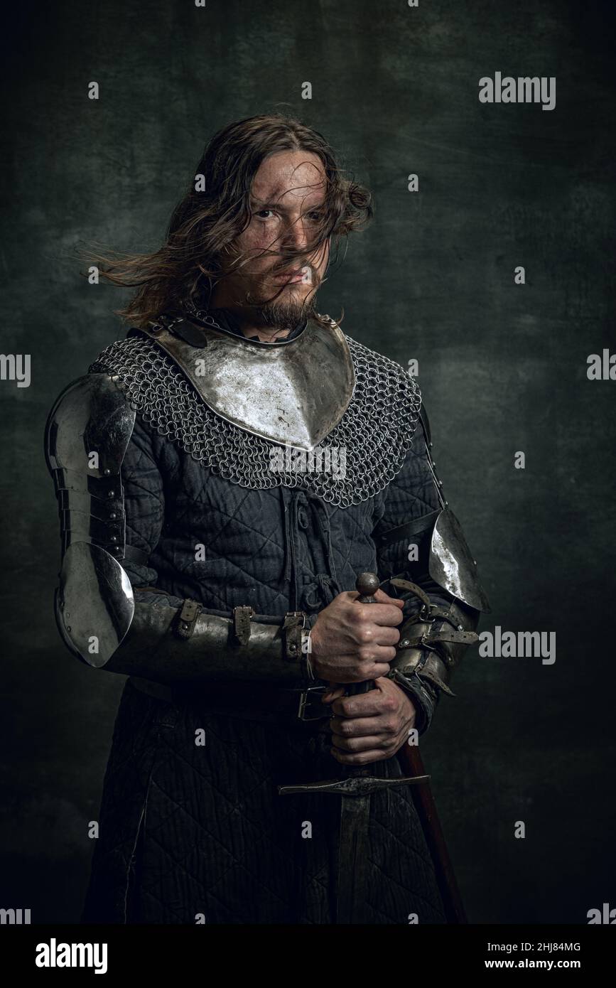 Portrait of medieval warrior or knight with dirty wounded face holding ...
