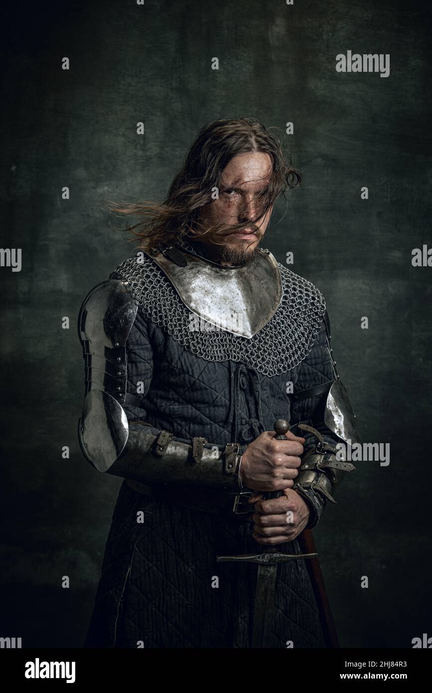Half-length portrait of brutal seriuos man in image of medieval warrior ...