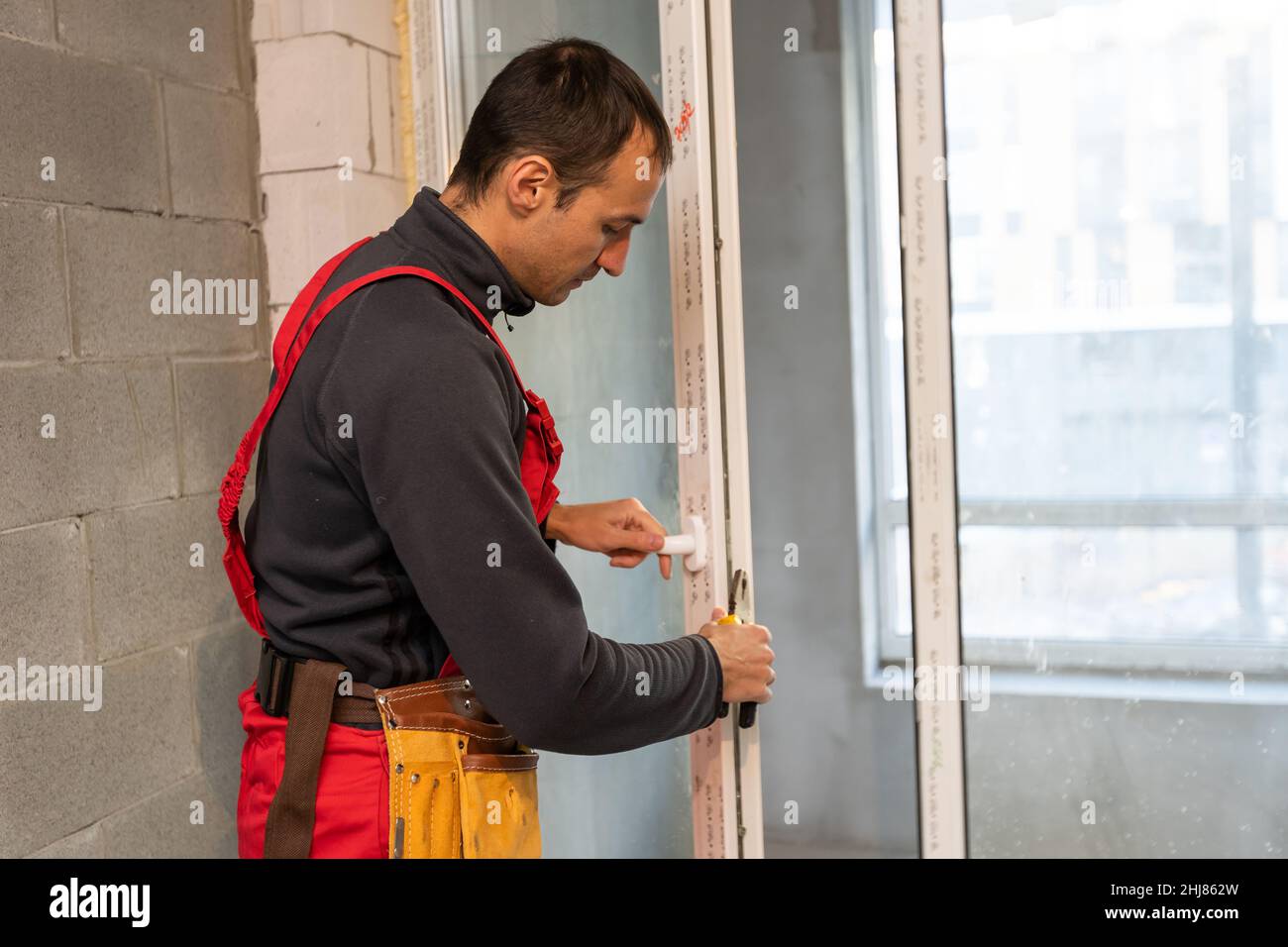 Construction worker repairing windows in house Stock Photo - Alamy