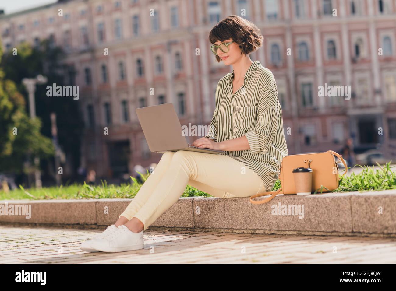 Photo of freelancer worker agent sit street work laptop typing wear ...