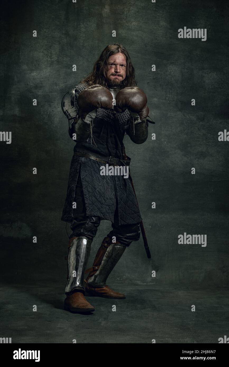 Portrait of medieval warrior or knight with dirty wounded face boxing ...