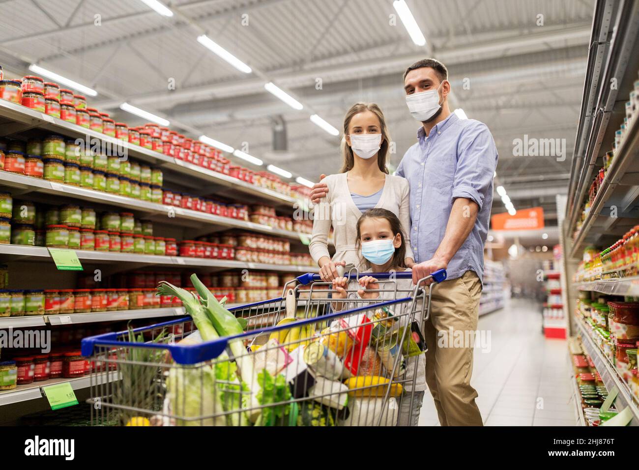 family with shopping cart in masks at supermarket Stock Photo - Alamy